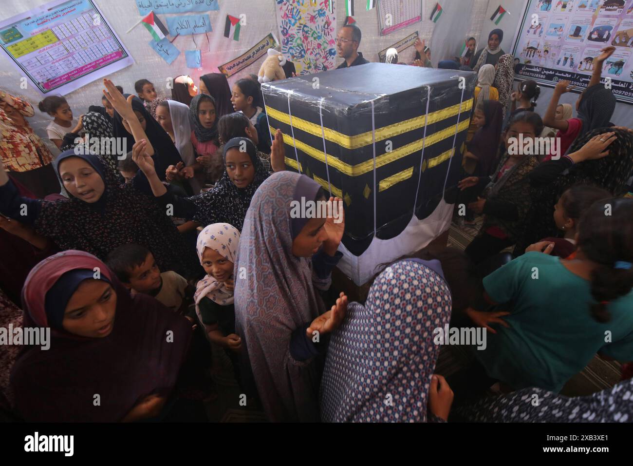 Displaced Palestinian children gather around a makeshift cube ...