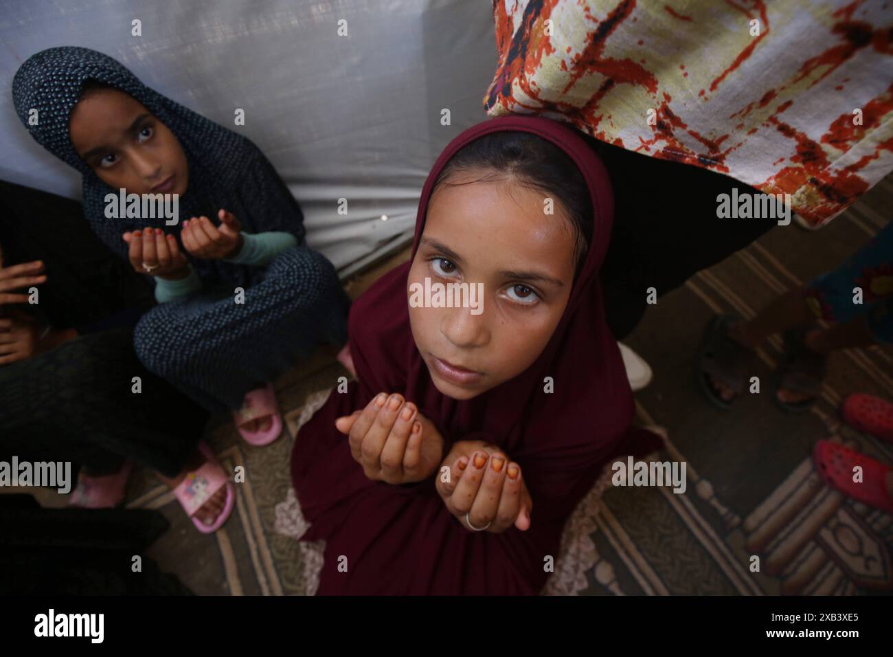 Displaced Palestinian children gather around a makeshift cube ...