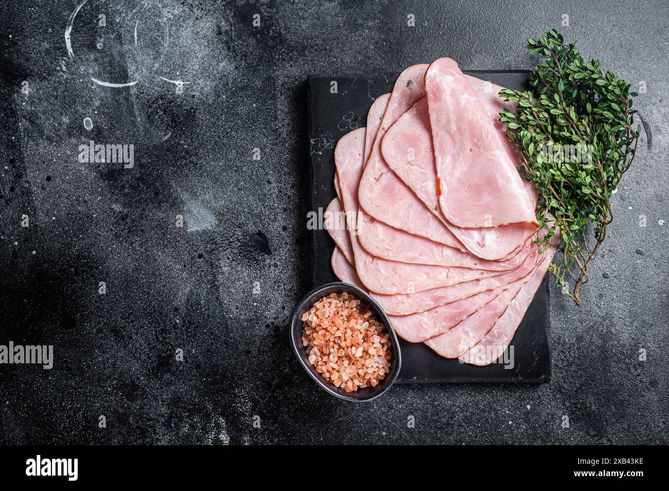 Squared slices of lean pork ham. Black background. Top view. Copy space ...
