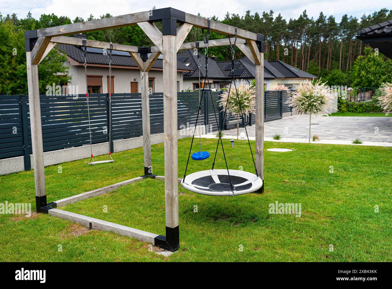 A modern, square-shaped wooden playground, made of metal corners ...