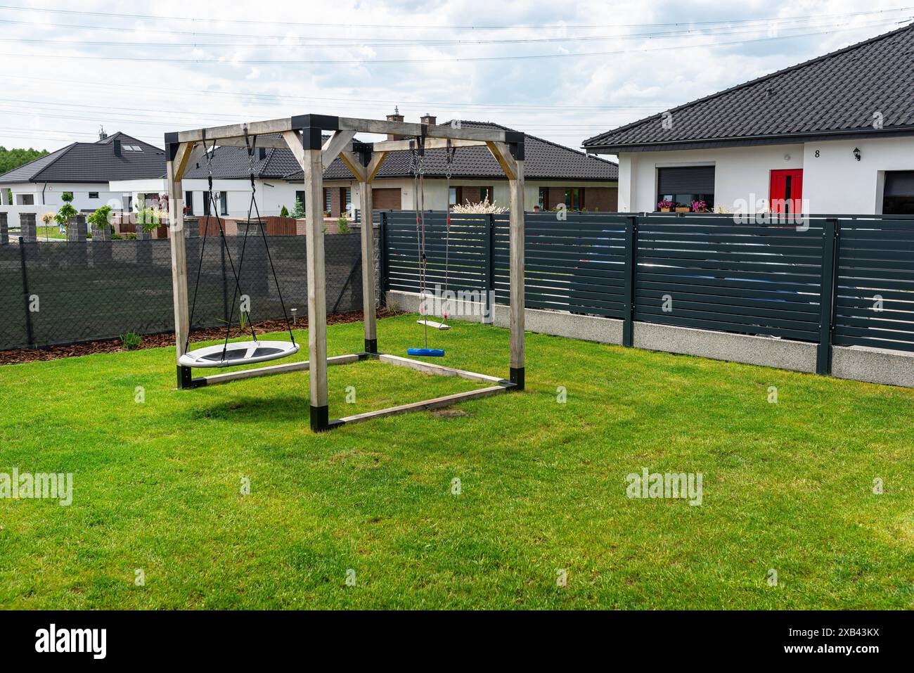 A modern, square-shaped wooden playground, made of metal corners ...