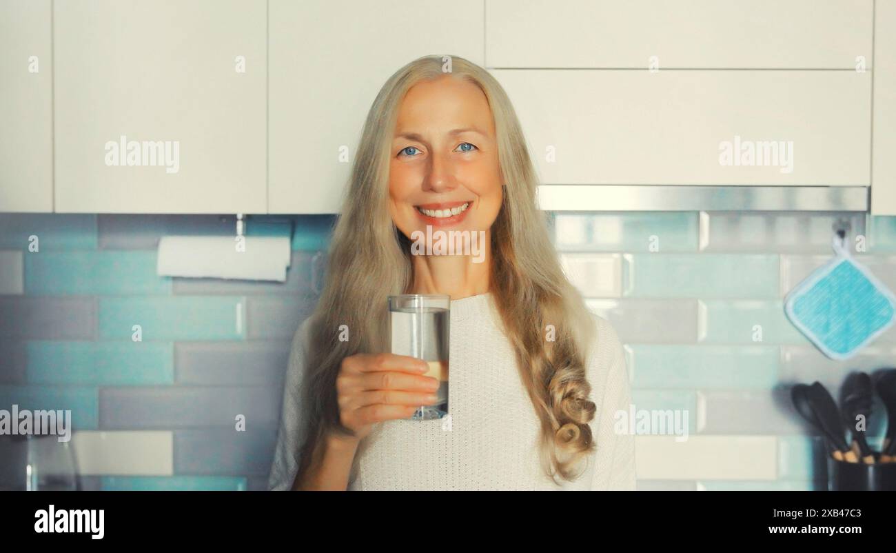 Portrait of happy smiling middle-aged gray-haired woman holds glass ...