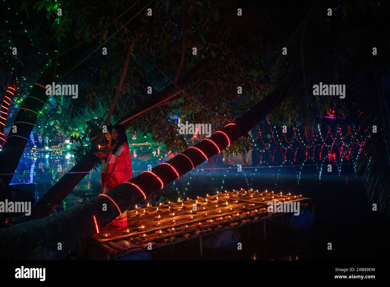 Young women illuminate Diwali lamps at the pond of Sri Sri Baradeswari ...