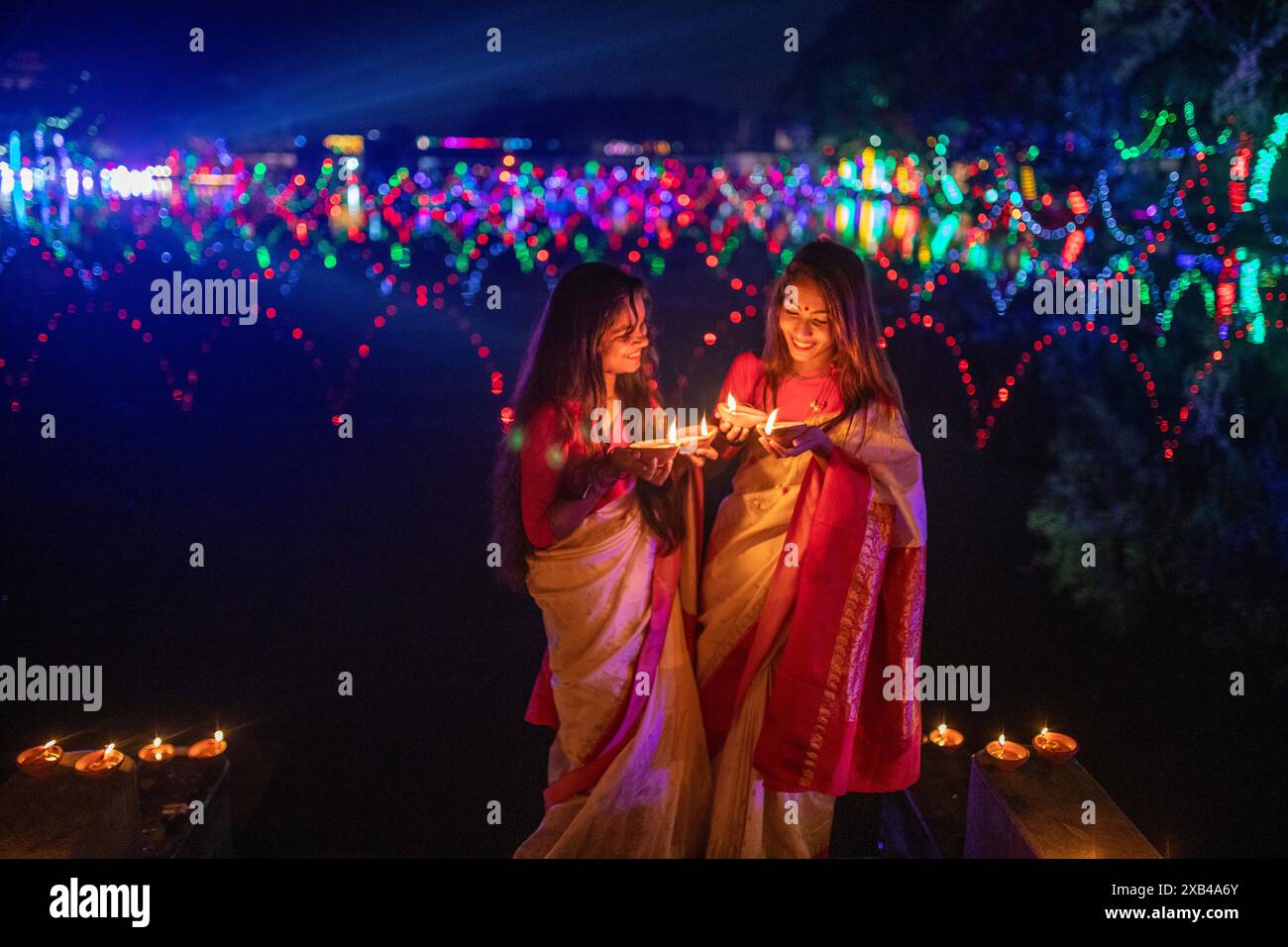 Young women illuminate Diwali lamps at the pond of Sri Sri Baradeswari ...