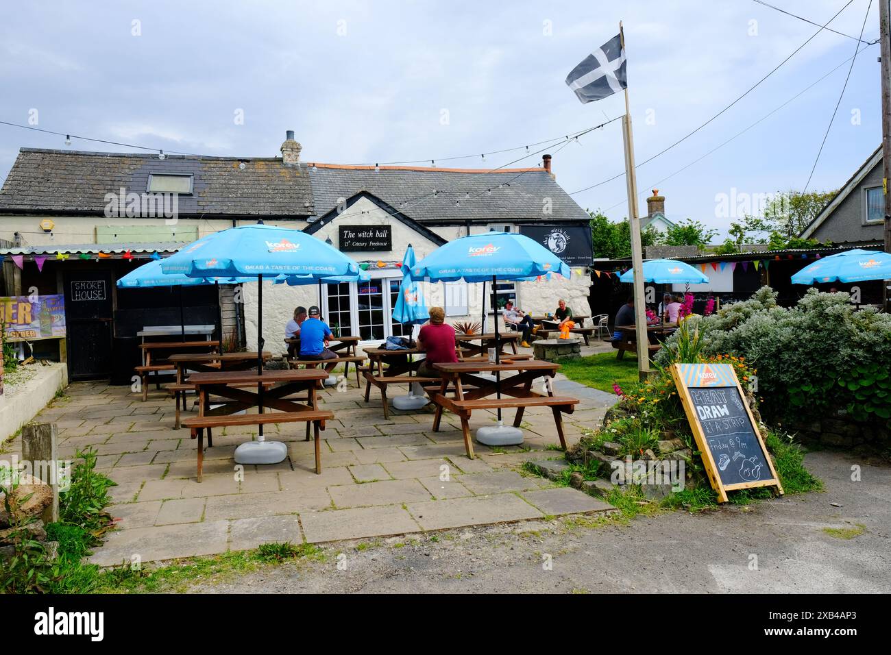 Tourists eating and drinking in the Witch Ball pub garden at the Lizard ...
