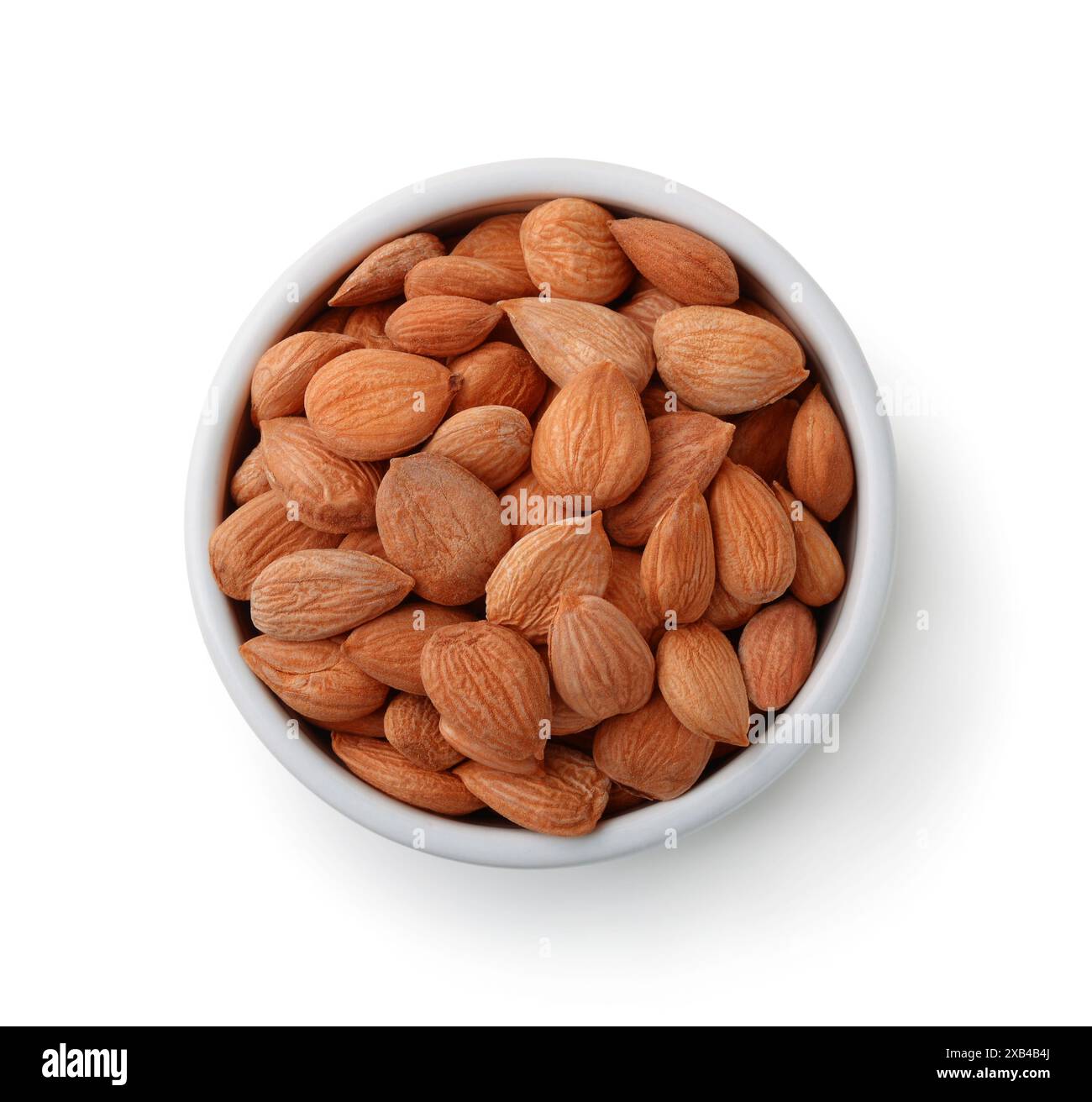 Top view of peeled apricot kernels in ceramic bowl isolated on white ...