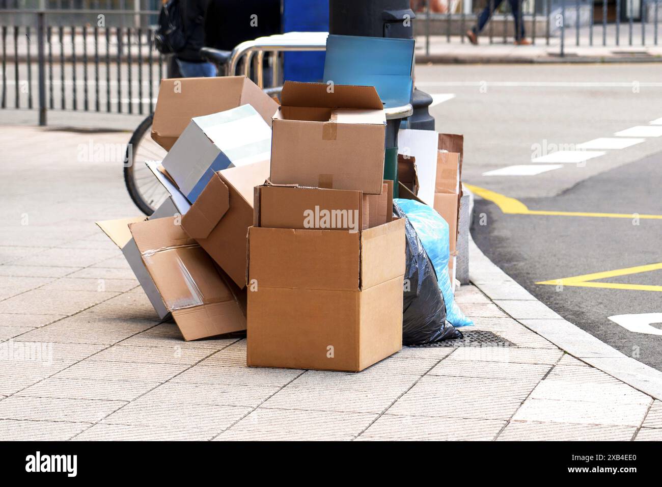 A pile of cardboard boxes and plastic bags with garbage thrown into the ...