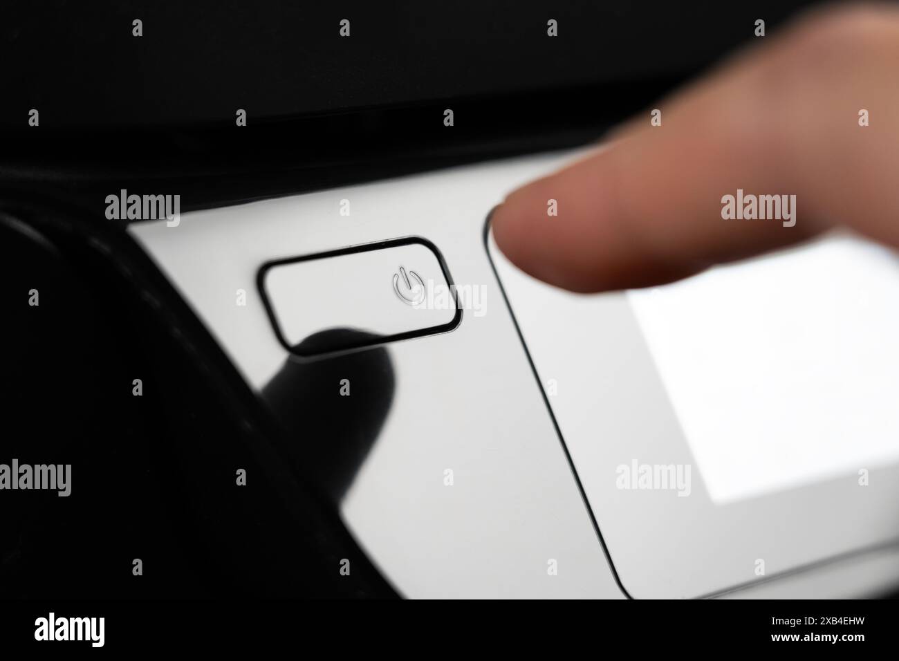 Finger pressing the button to turn on copy machine and scanner. Using ...