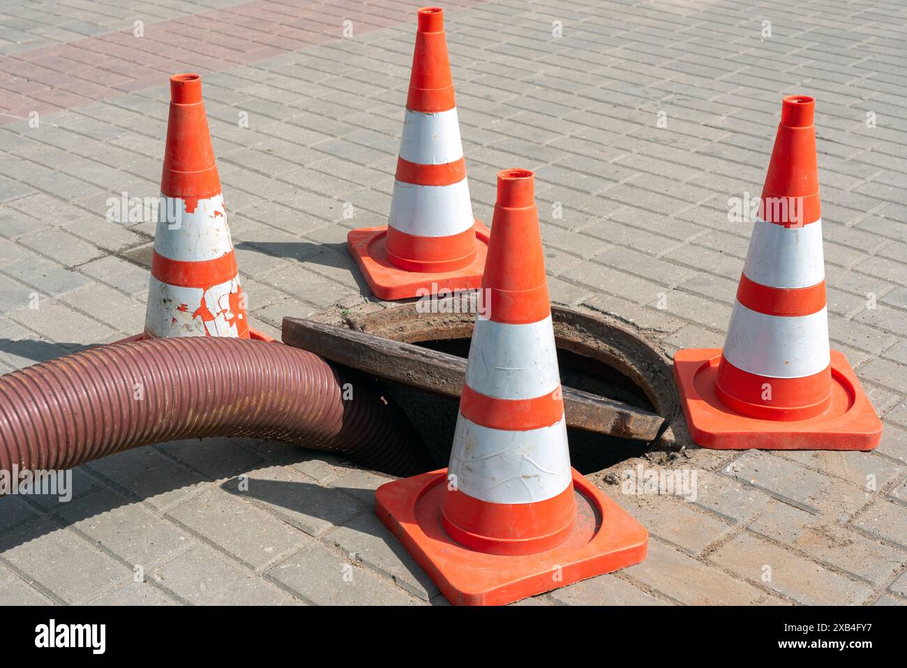 An open sewer manhole on a city street. Repair of city sewerage and ...