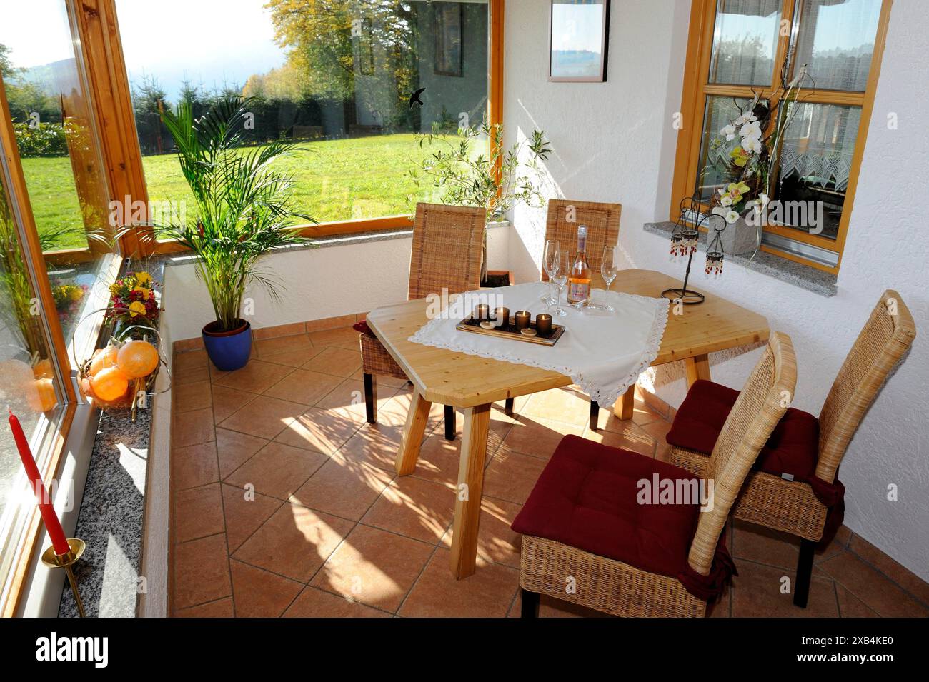 Cosy conservatory as a dining area with wooden table and chairs ...