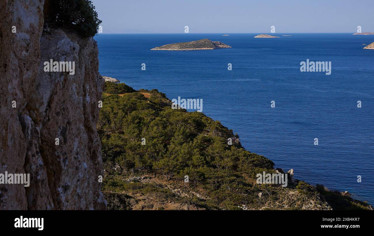 View of the sea with distant islands and a rocky, overgrown coast ...