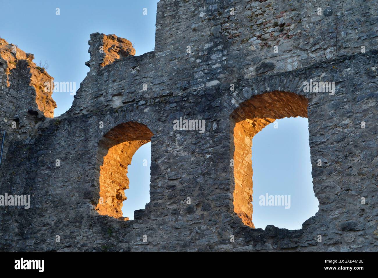 Old stone ruins with two window openings, illuminated by the warm light ...