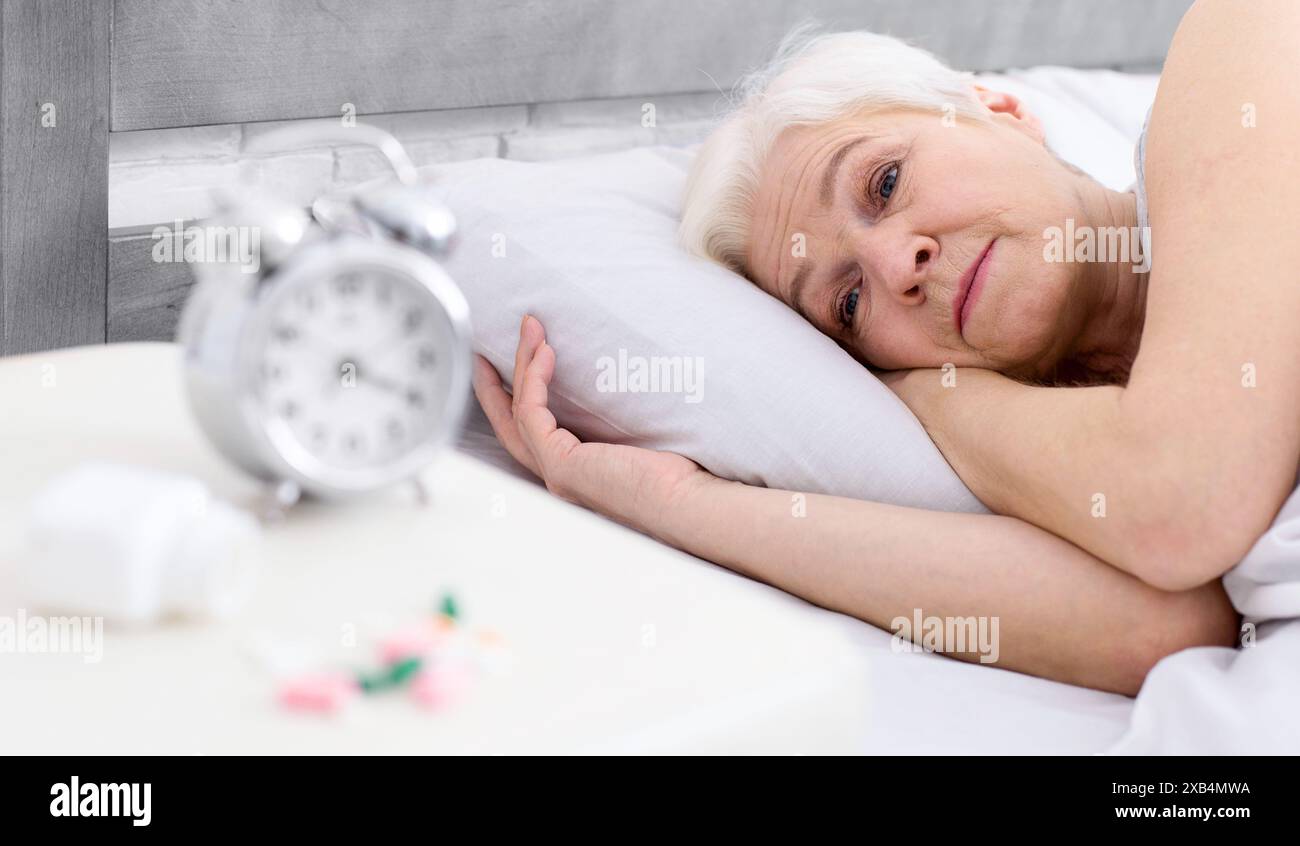 Woman Laying in Bed With Alarm Clock Stock Photo - Alamy