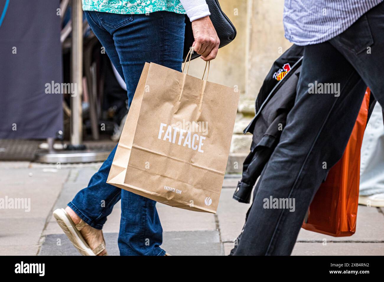 Female person walking carrying a branded carrier bag from high-street ...