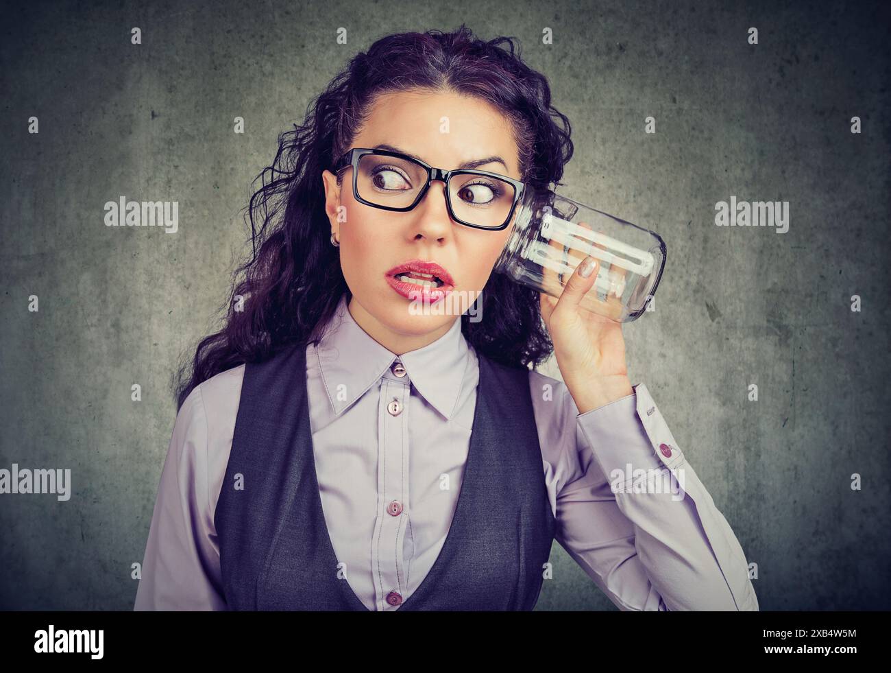 Funny looking woman listening to a secret conversation Stock Photo - Alamy