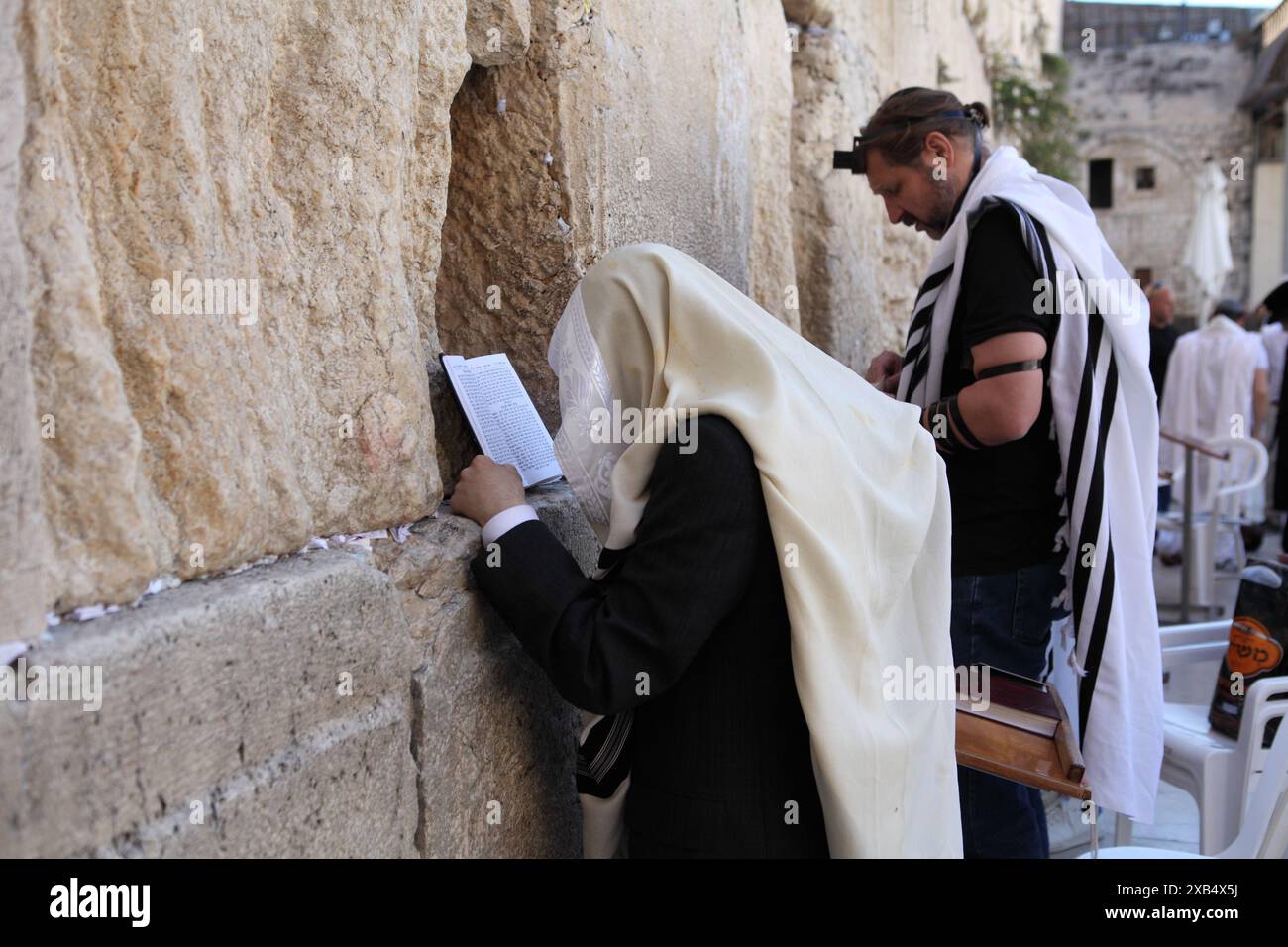 Ultra Orthodox Jew wrapped in a Talith holds a prayer book prays and ...