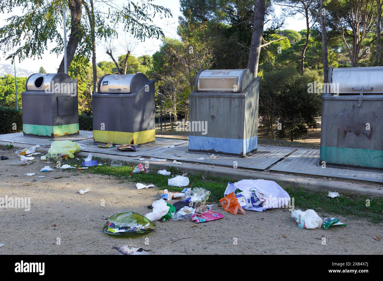 Trash bags thrown and open on street next to trash and recycling bins ...