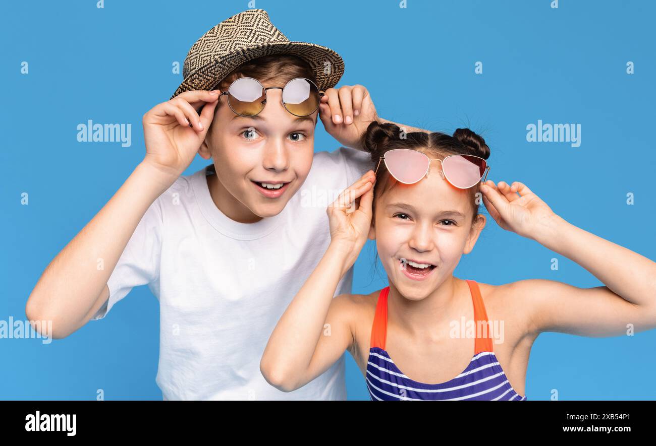 Happy Siblings Wearing Sunglasses Against Blue Background Enjoying ...