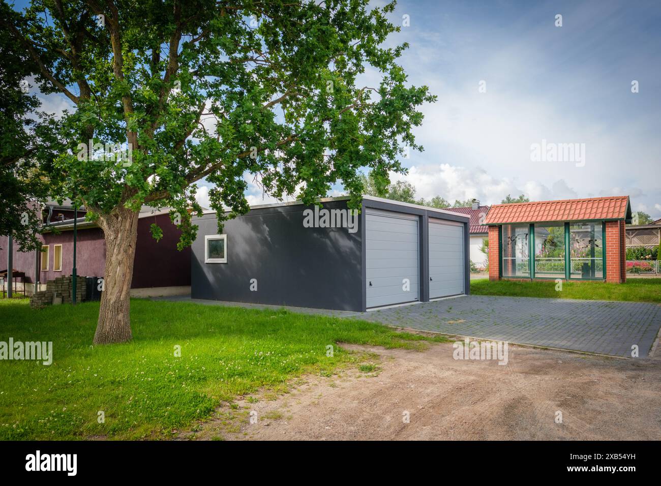 Anewly built double garage with roller doors stands under a tree Stock ...