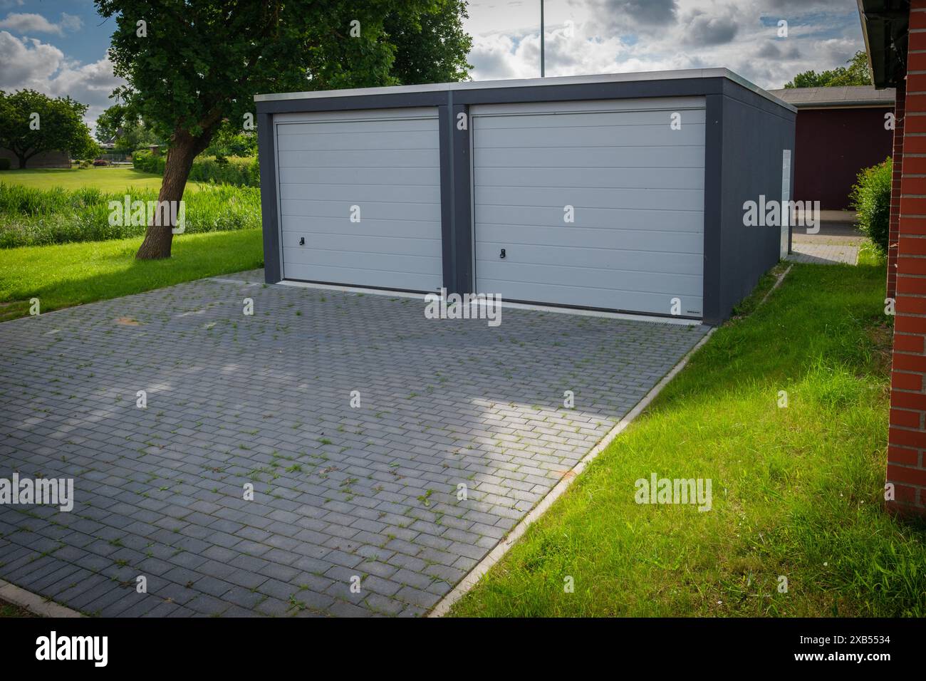 Anewly built double garage with roller doors stands under a tree Stock ...