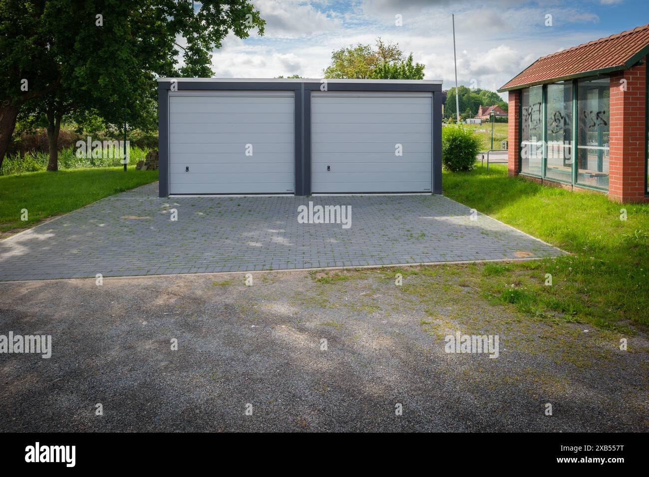 Anewly built double garage with roller doors stands under a tree Stock ...