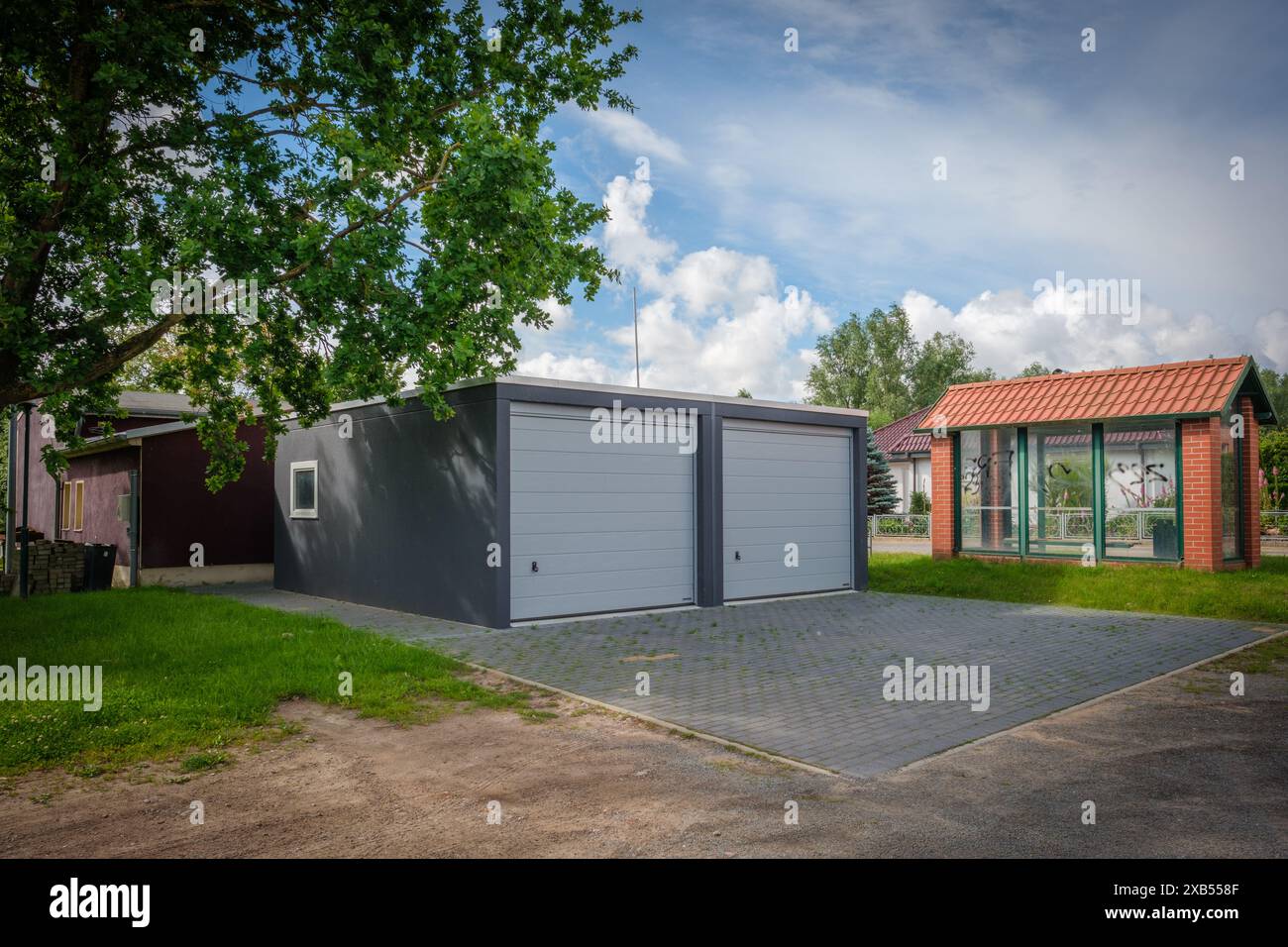 Anewly built double garage with roller doors stands under a tree Stock ...