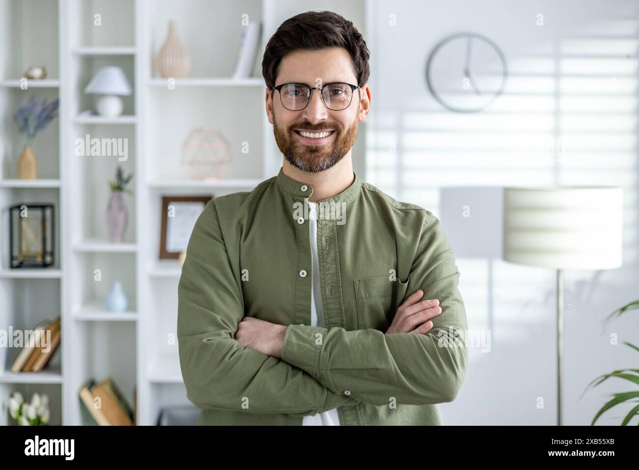 Smiling confident young businessman crossing hi-res stock photography ...