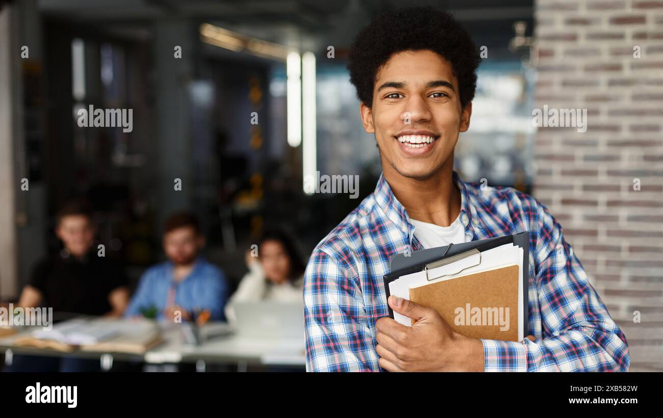 Happy student with books looking at camera in library Stock Photo - Alamy