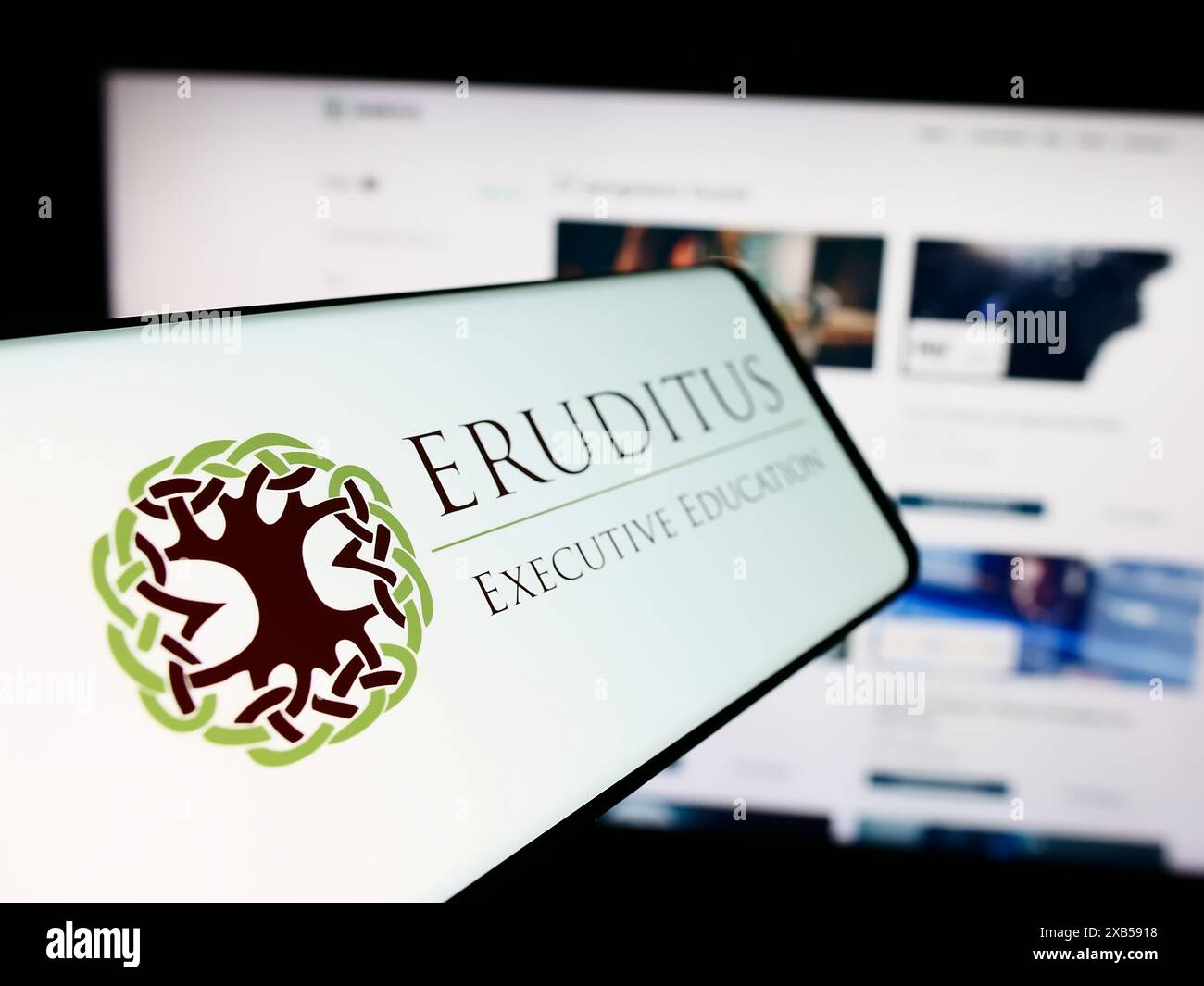 Mobile phone with logo of Singaporean company Eruditus Executive Education in front of business ...