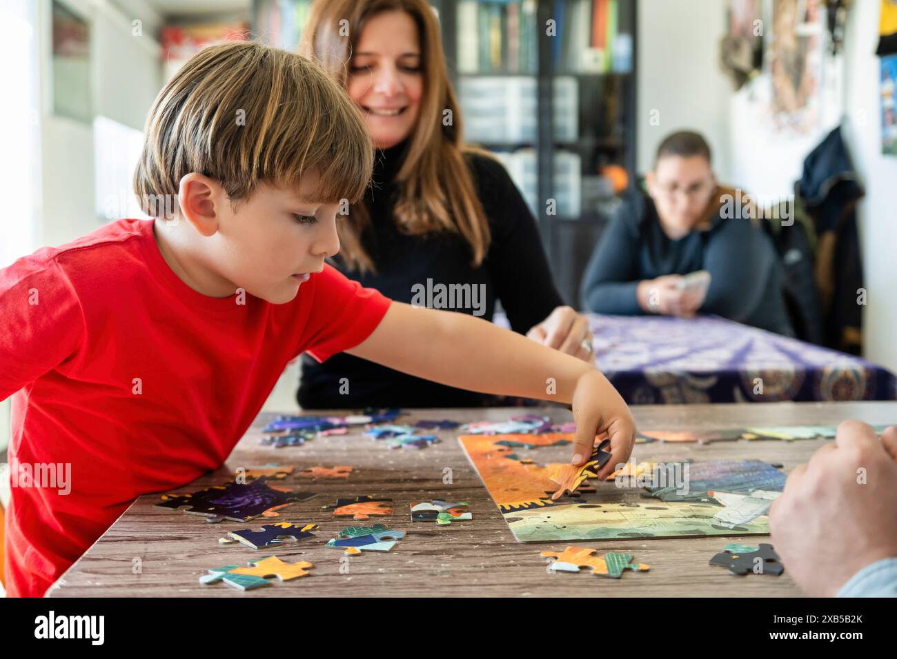 Family playing with jigsaw puzzle hi-res stock photography and images ...