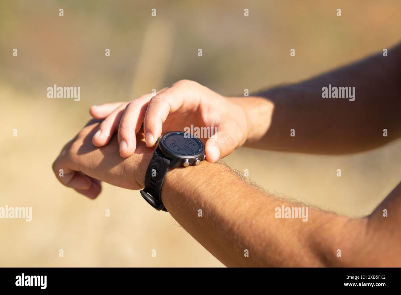 Runner on mountain forest trail checking looking at sport watch ...