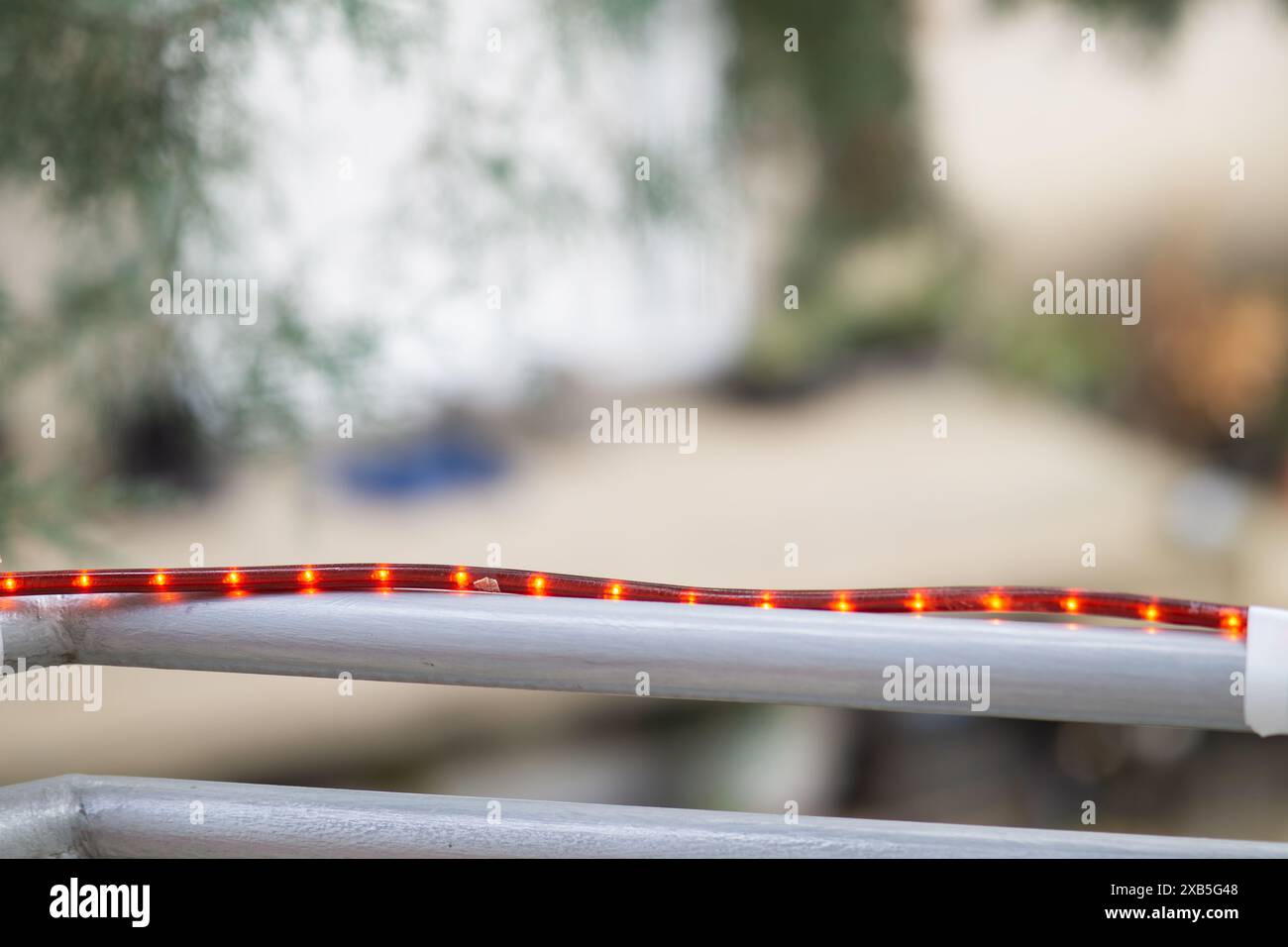 Christmas red string lights hose taped on a fence, decorating at home ...
