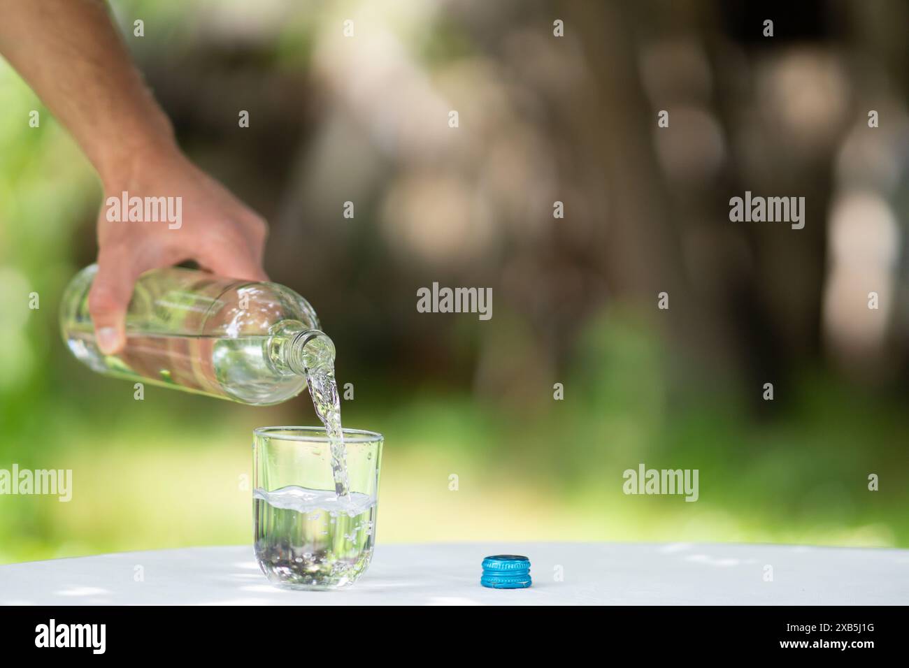 Hand pouring water from glass hi-res stock photography and images - Alamy