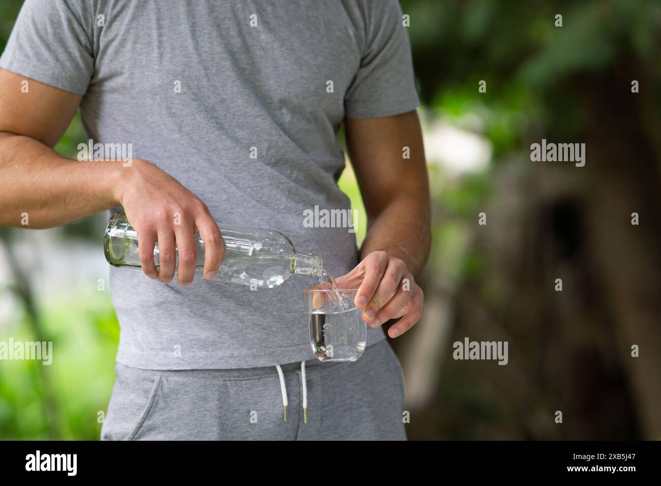 man pouring water from bottle into glass, pouring glass of water, bottle of glass water filling ...