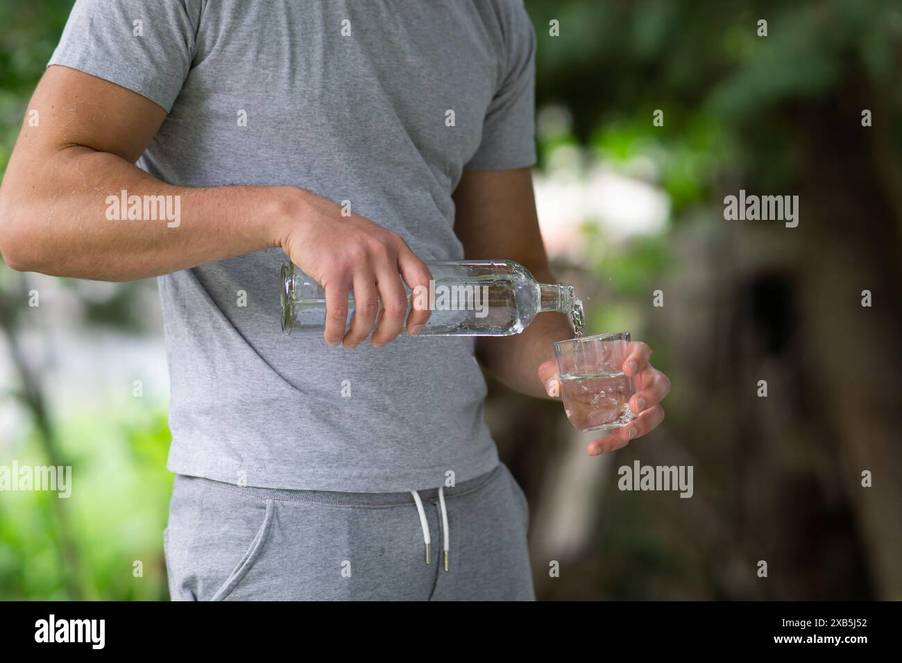 man pouring water from bottle into glass, pouring glass of water ...
