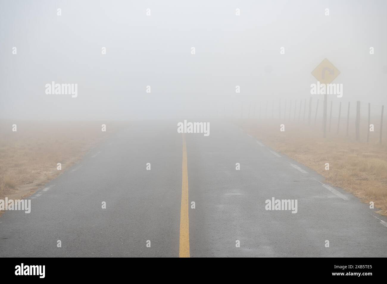 Thick fog en route, curve sign Stock Photo - Alamy