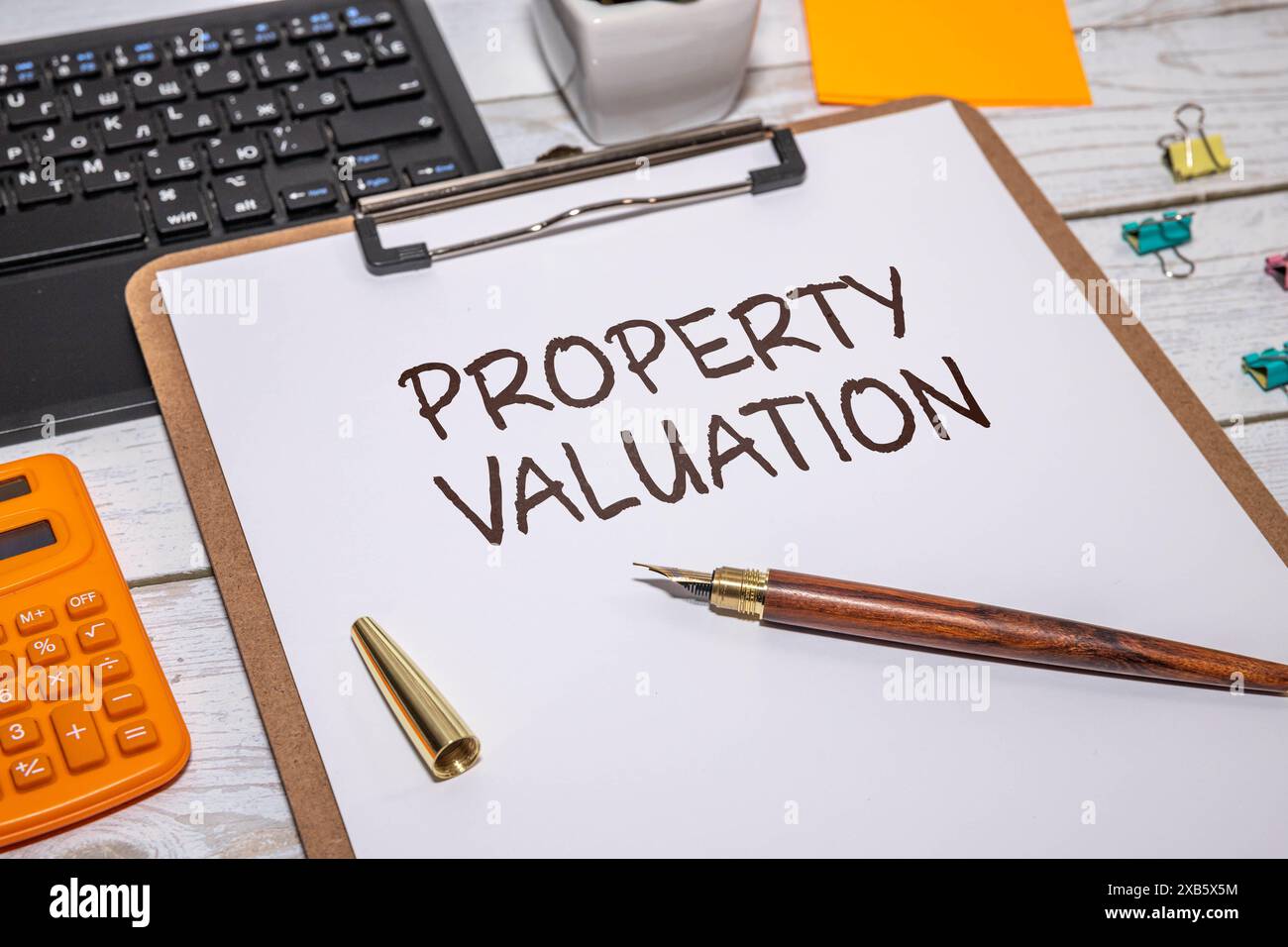 Property valuation text on notepad with house model and key on wooden ...