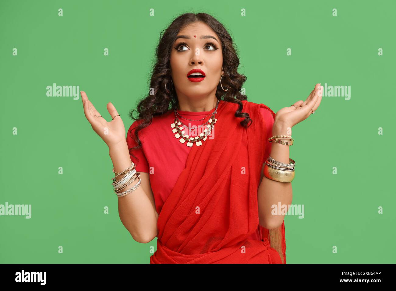 Beautiful shocked Indian woman in sari on green background Stock Photo ...