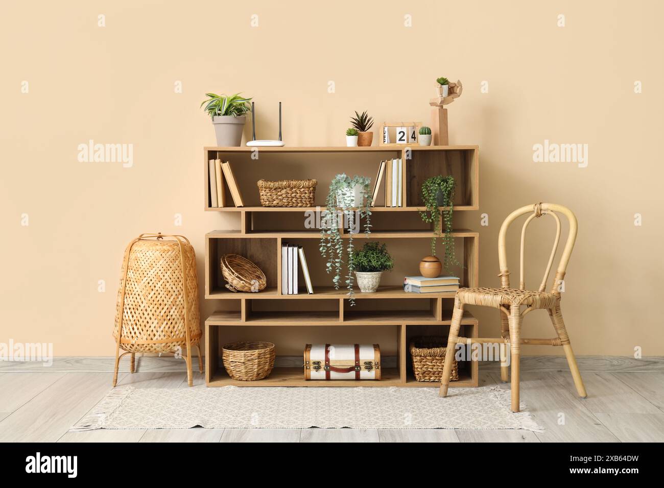 Bookshelf with modern wi-fi router and plants near beige wall in room ...