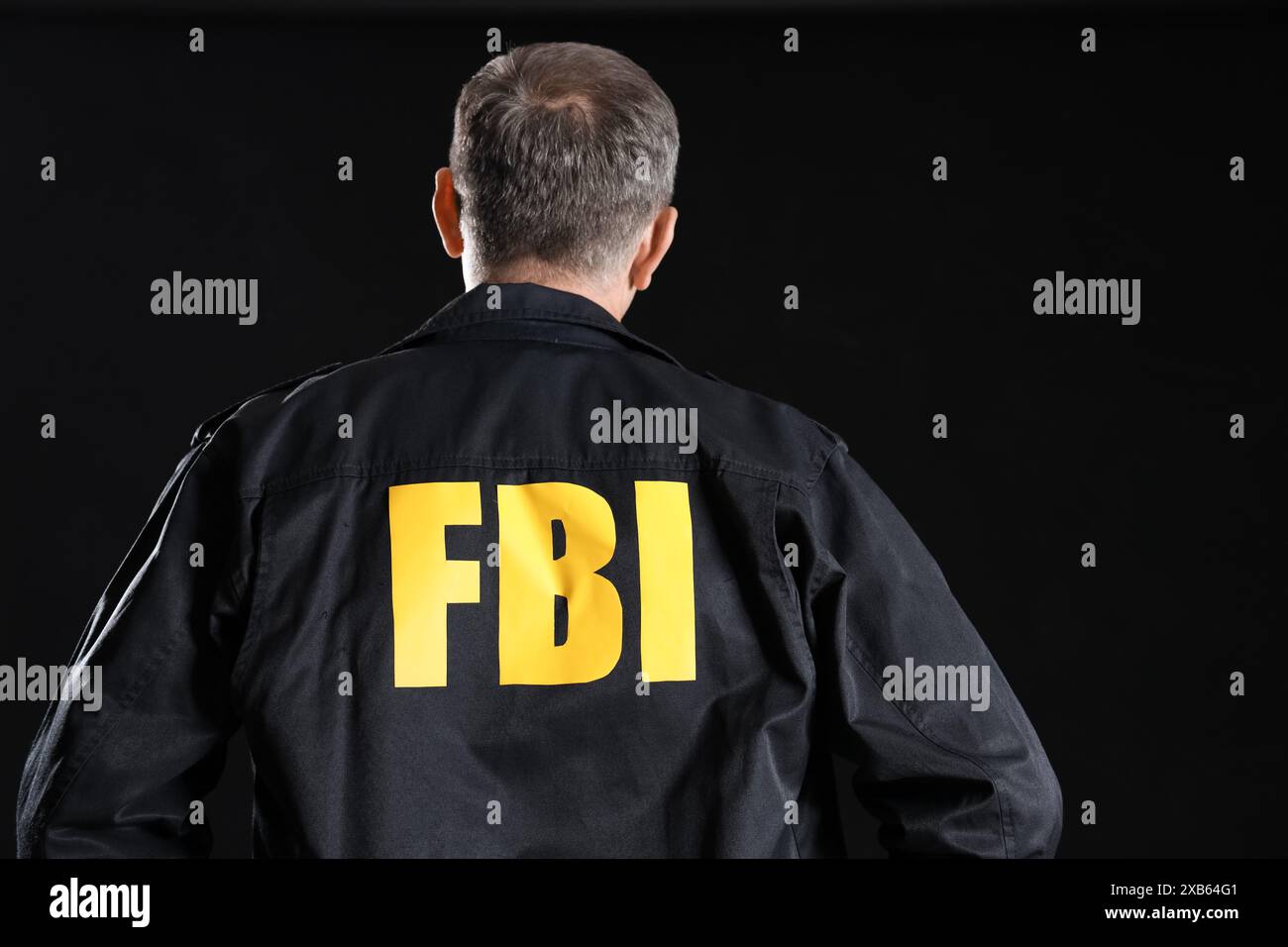 Mature FBI agent on black background, back view Stock Photo - Alamy