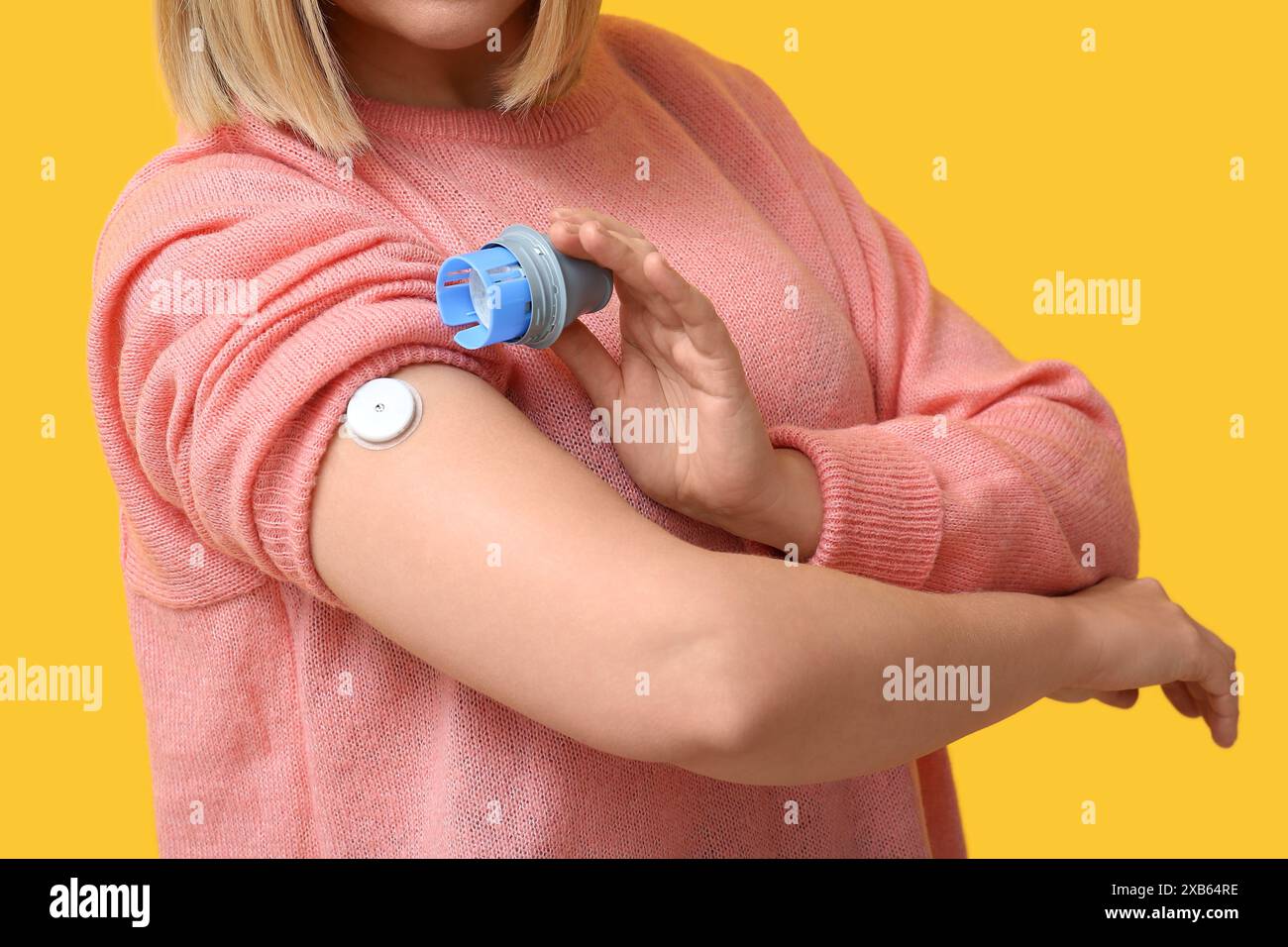 Woman with glucose sensor for measuring blood sugar level and ...