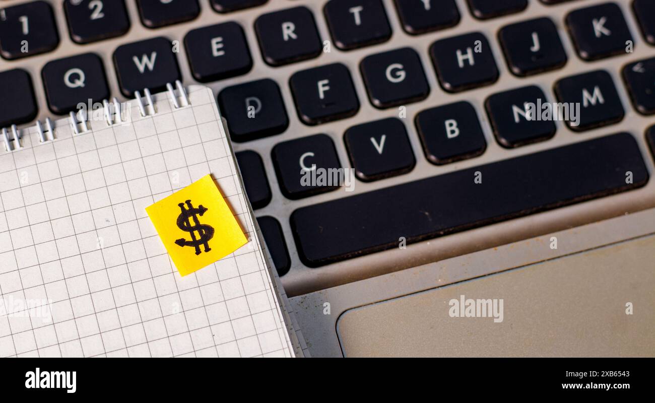 Laptop keyboard background with sticky notes depicting the dollar logo ...