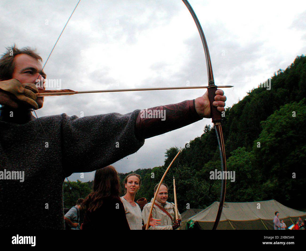 Archer with a bow and arrow aiming in the twilight Archer with bow and ...