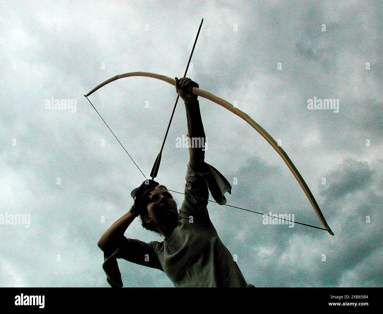 Archer with a bow and arrow aiming in the twilight Archer with bow and ...