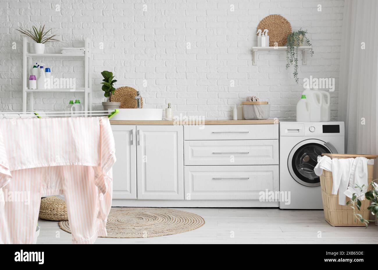 Interior of laundry room with washing machine, basket and counters ...