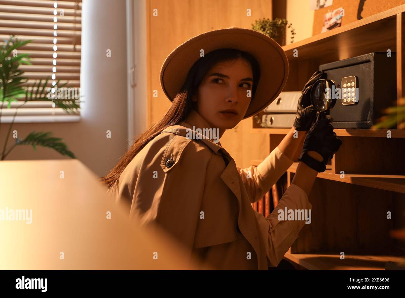 Female spy with magnifier breaking into safe in office at night Stock ...