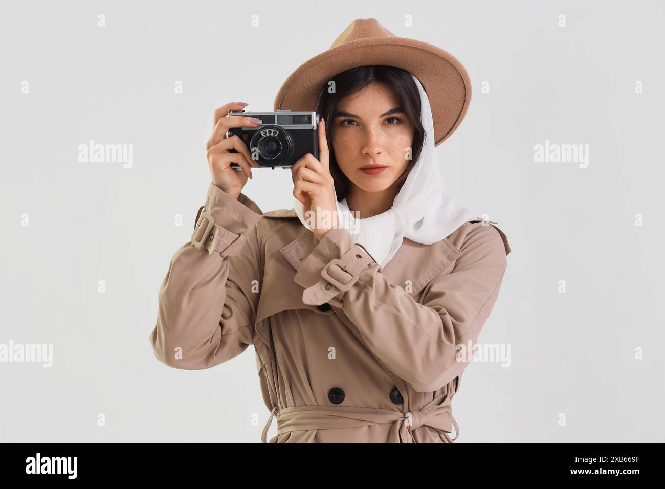 Female spy with photo camera on light background Stock Photo - Alamy