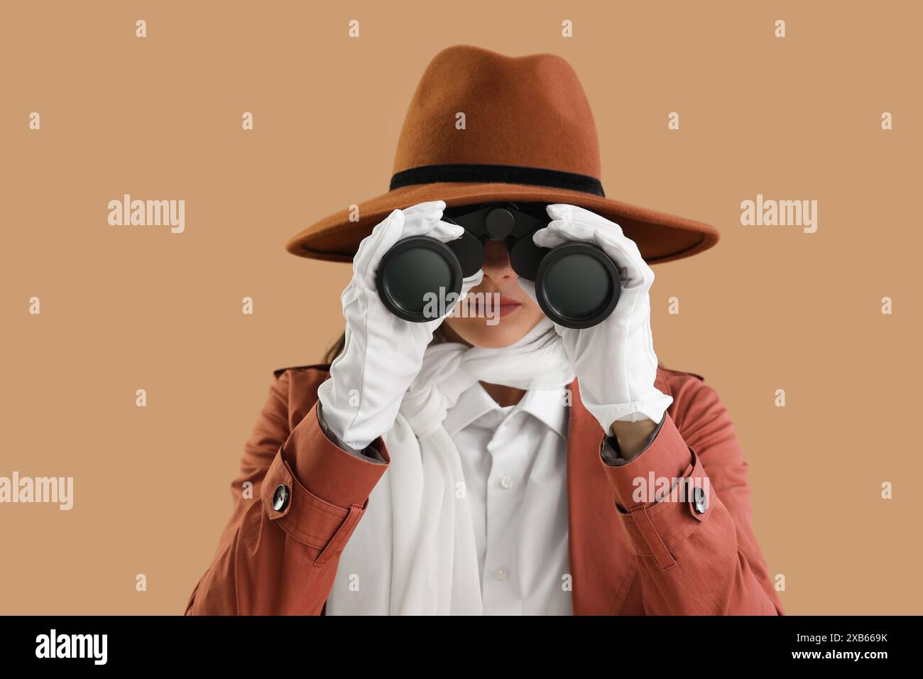 Female spy looking through binoculars on beige background, closeup ...