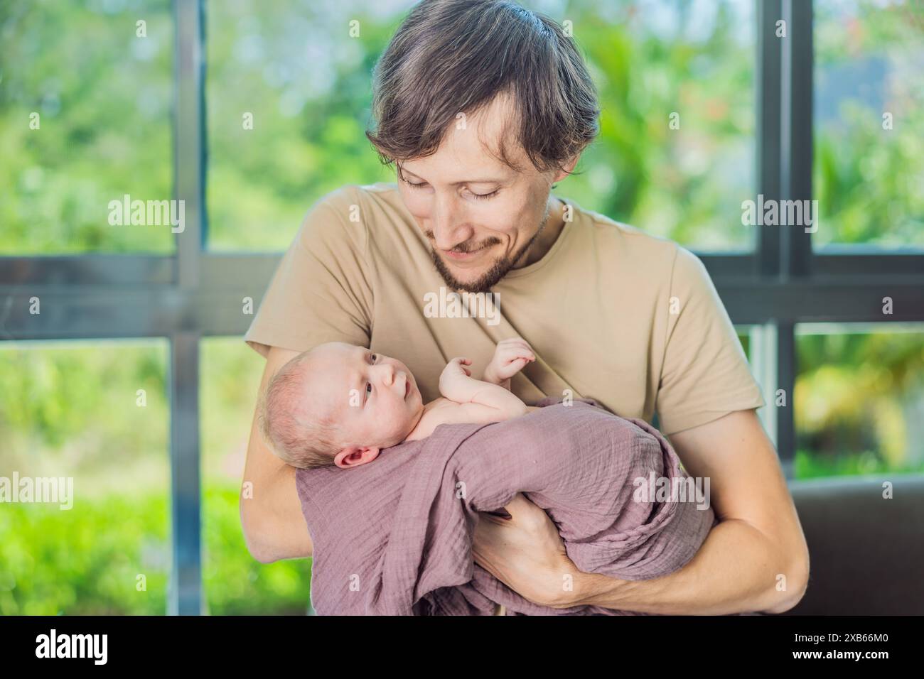 Dad and newborn at home. This tender moment captures the bond between ...