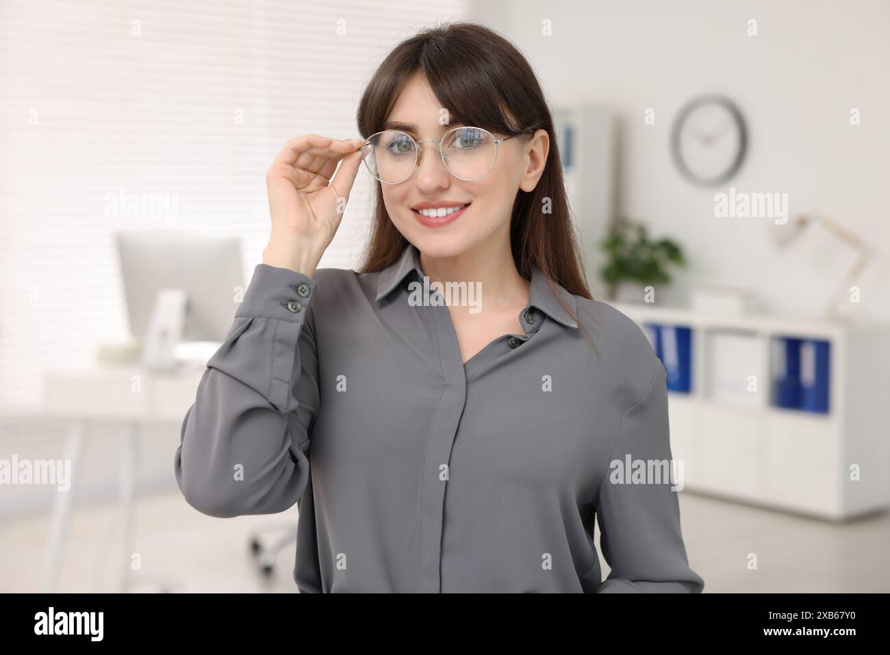 Portrait of smiling secretary wearing glasses in office Stock Photo - Alamy